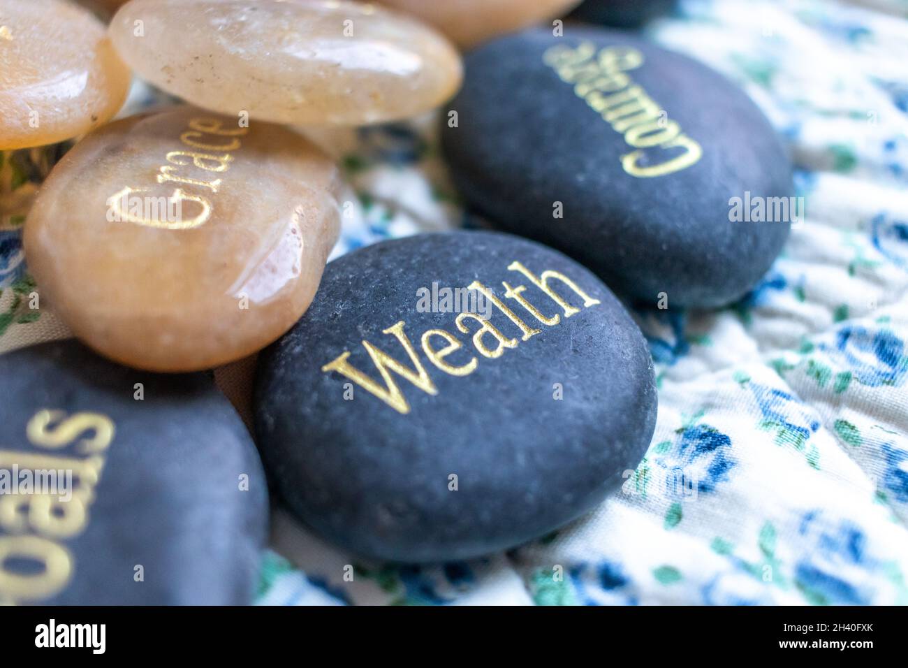 Wealth zen stone on a golden background Stock Photo - Alamy