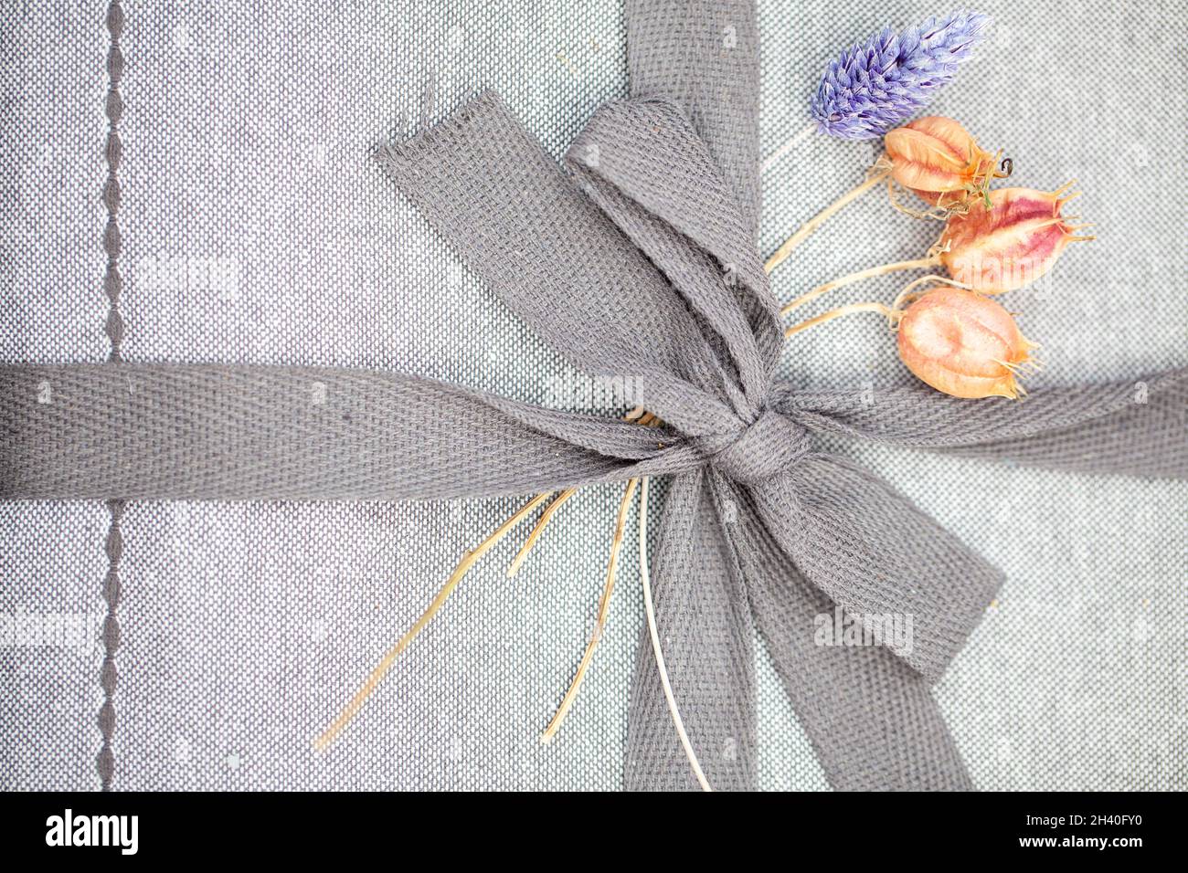 Close up cute grey ribbon bow on a grey linnen package Stock Photo - Alamy