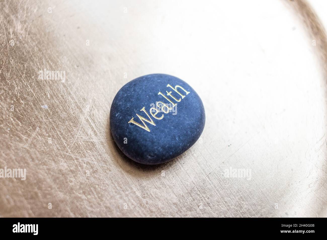 Wealth zen stone on a golden background Stock Photo - Alamy