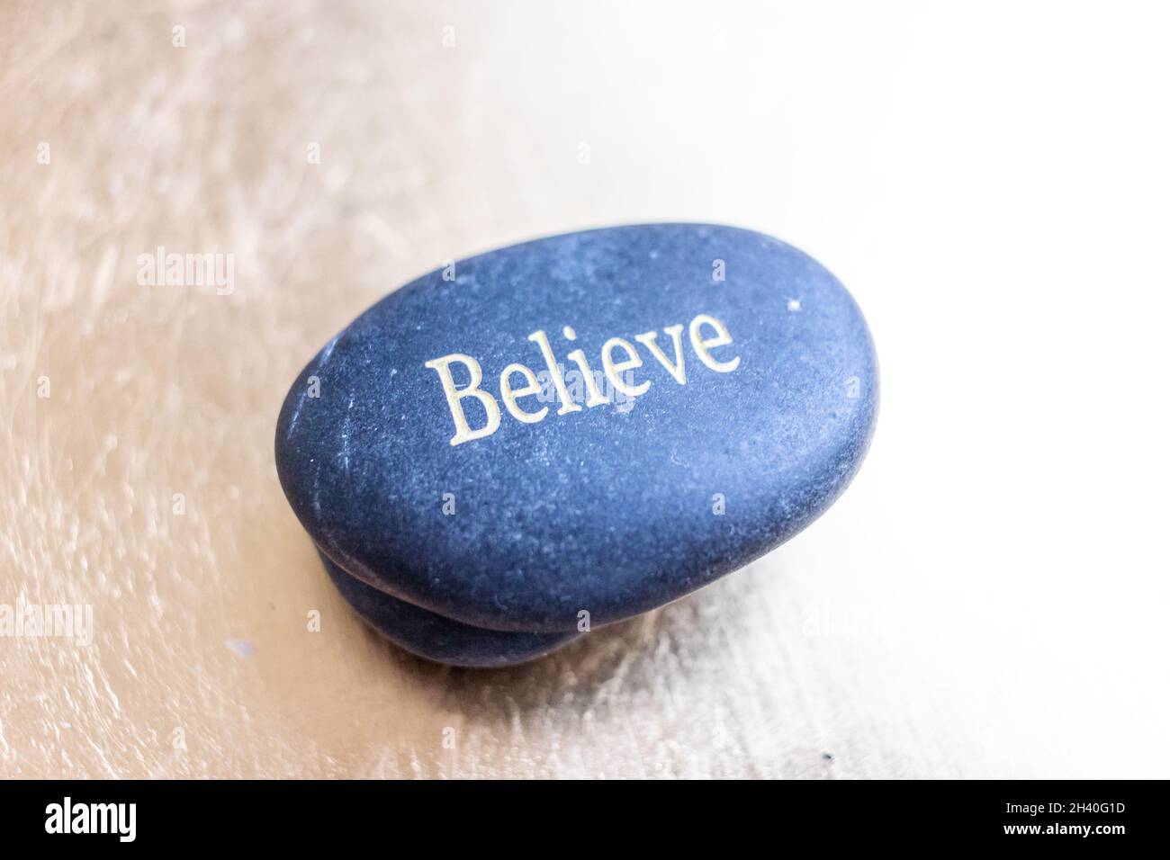 Inspire, Believe engraved zen stone on a golden background Stock Photo ...