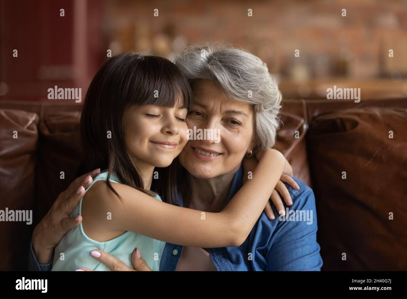 Happy peaceful loving grandchild and grandma hugging cheek to cheek ...