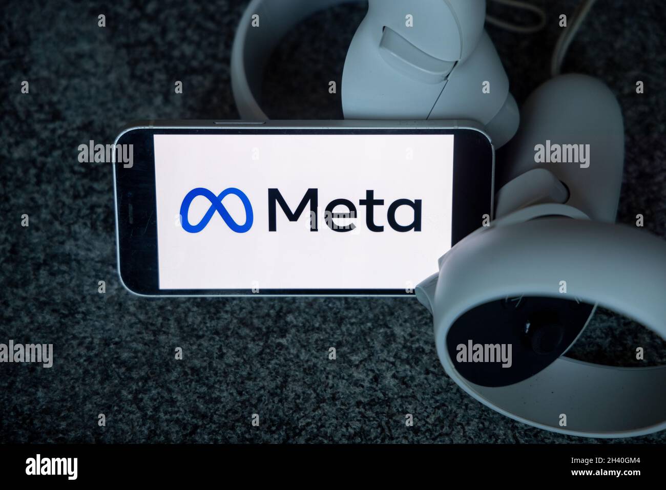 META company logo on smartphone next to Oculus joy cons, touch ...