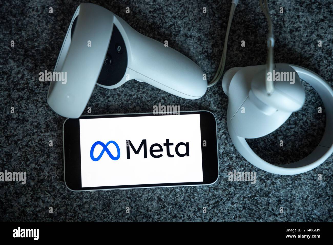 META company logo on smartphone next to Oculus joy cons, touch ...