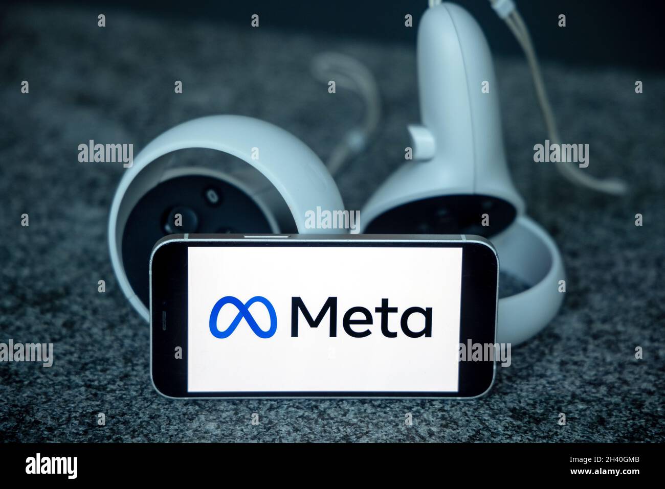 META company logo on smartphone next to Oculus joy cons, touch ...