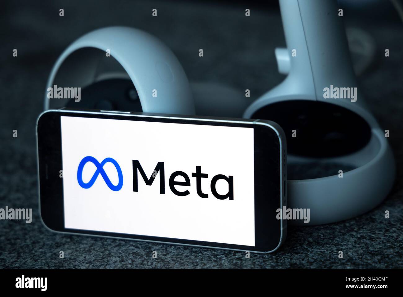 META company logo on smartphone next to Oculus joy cons, touch ...