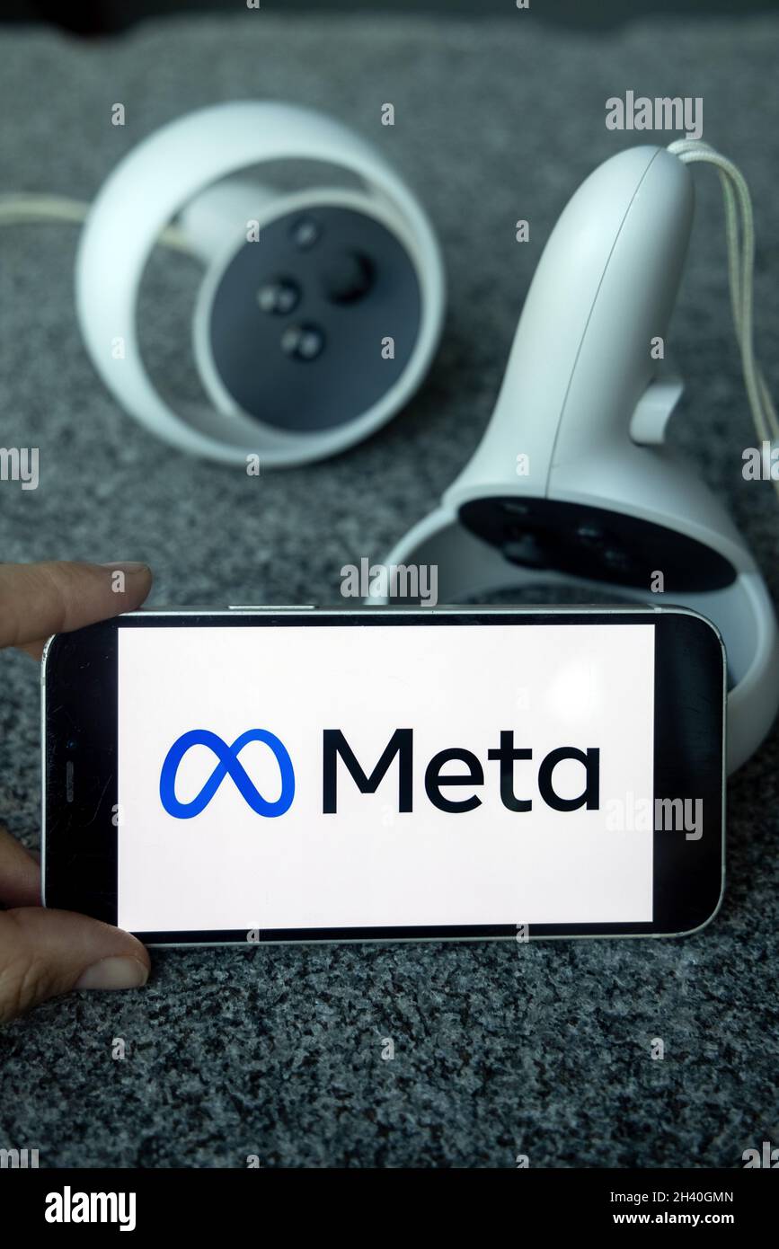 META company logo on smartphone next to Oculus joy cons, touch ...
