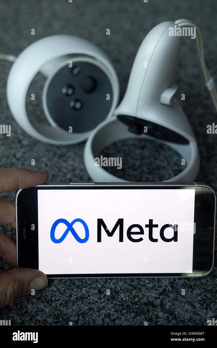 META company logo on smartphone next to Oculus joy cons, touch ...