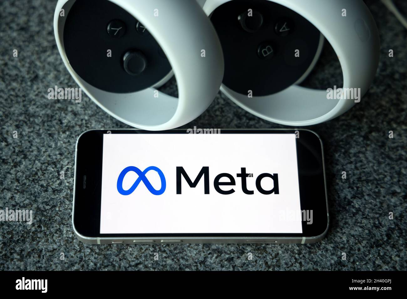 META company logo on smartphone next to Oculus joy cons, touch ...