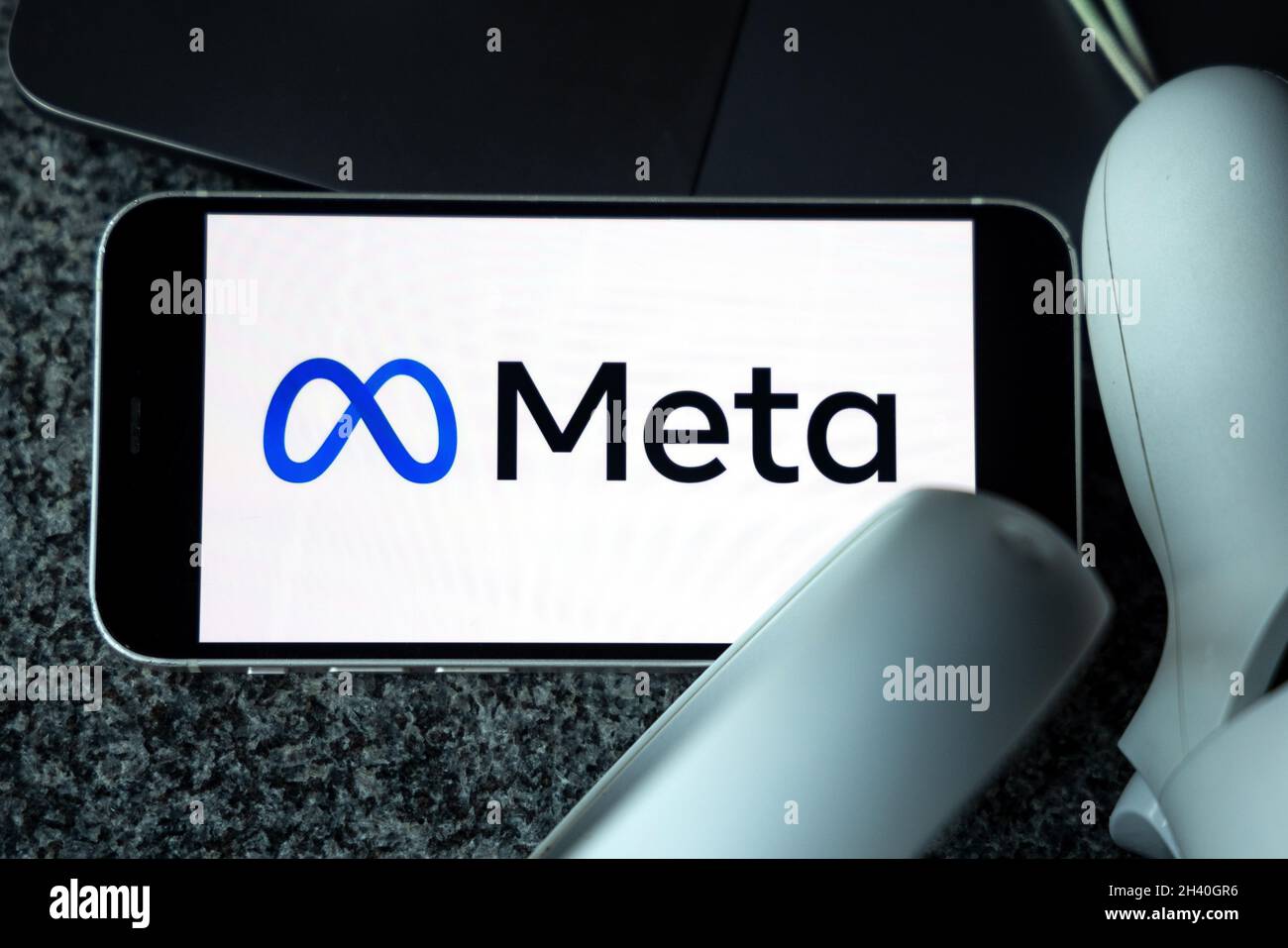 META company logo on smartphone next to Oculus joy cons, touch ...