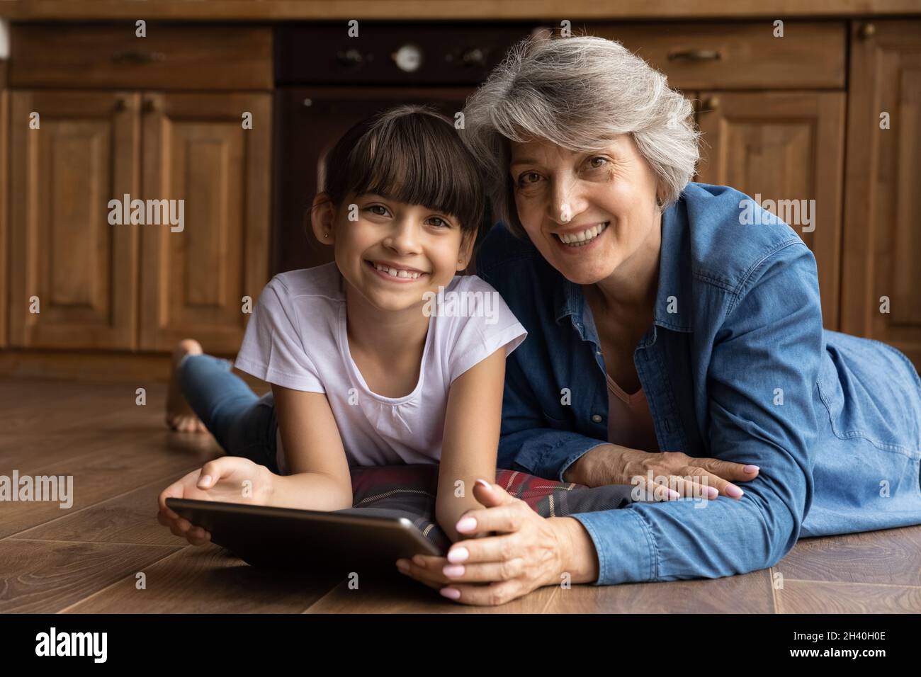 Happy grandma and cute gen Z granddaughter girl holding tablet Stock ...