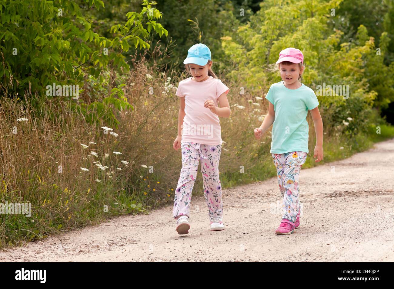 Two elementary school age girls wandering, children, sisters walking ...