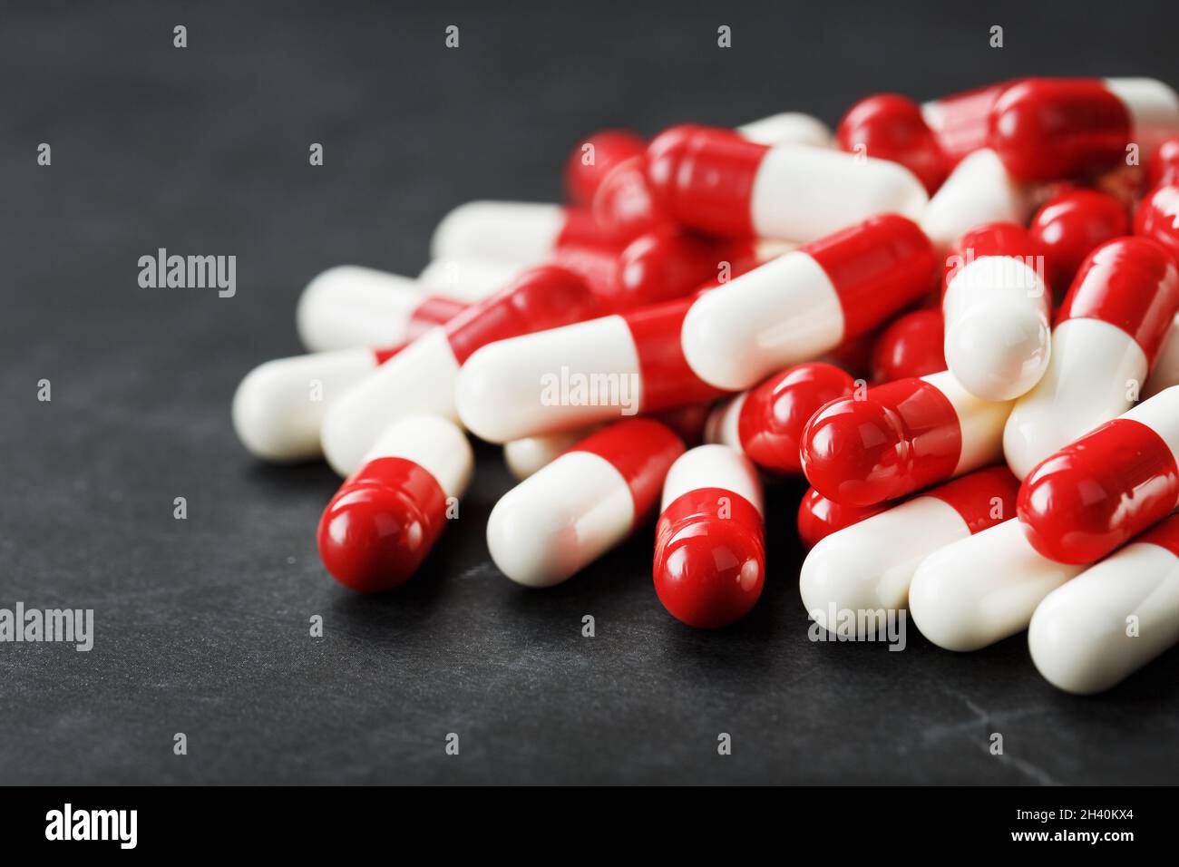 Medical red and white capsules isolated on a black background. Capsules ...