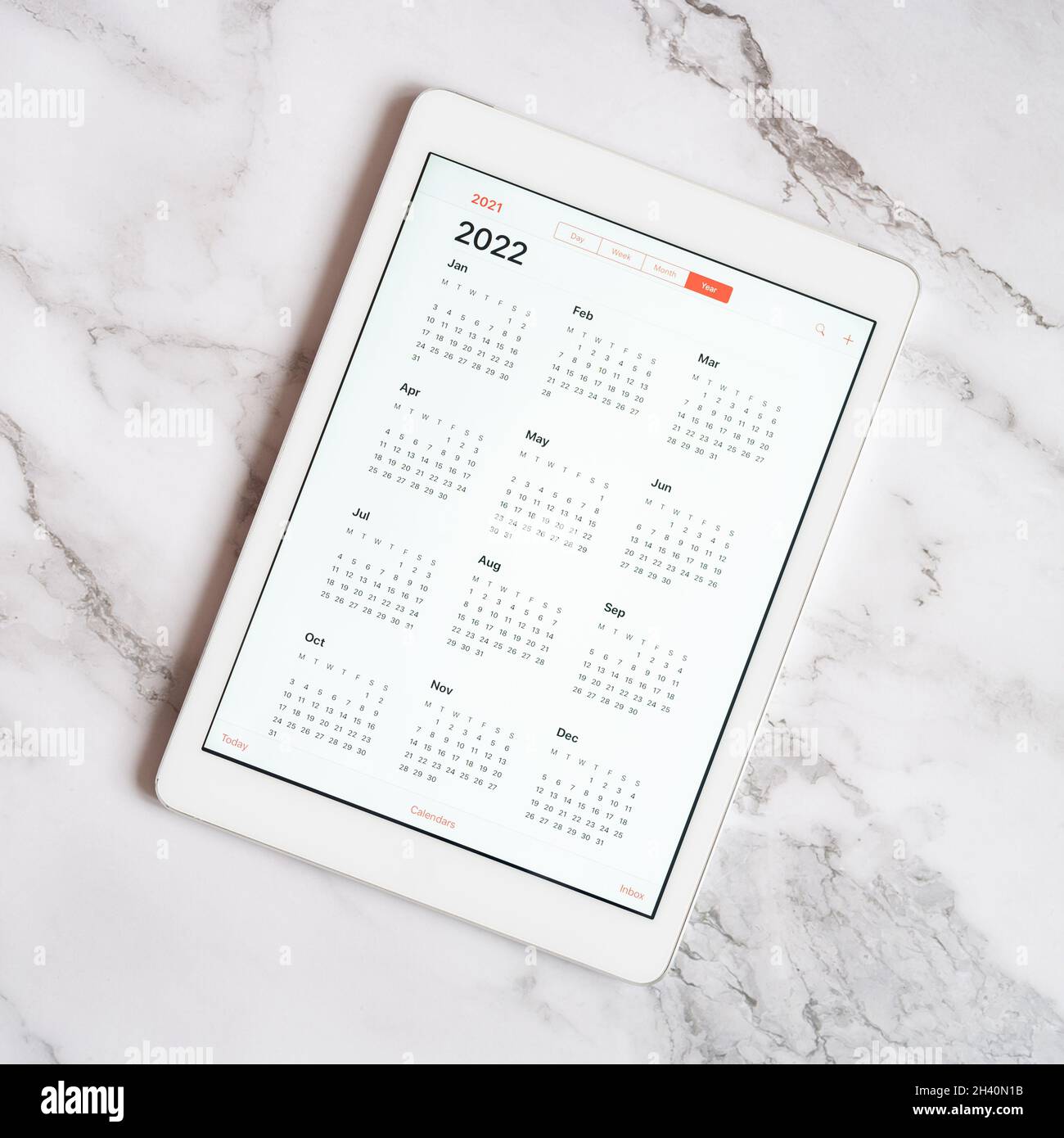 tablet computer with an open app of calendar for 2022 year on a gray ...