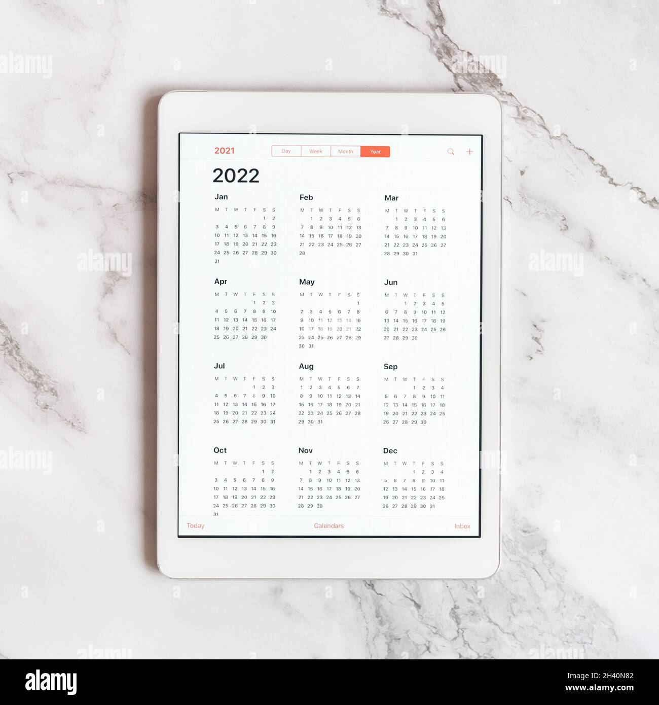 tablet computer with an open app of calendar for 2022 year on a gray ...