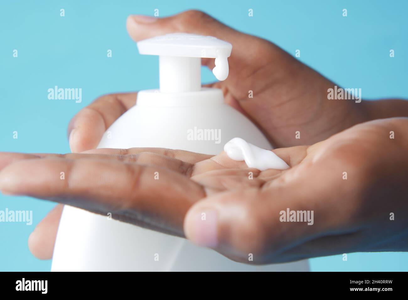 young man pouring moisturizing cream from a container Stock Photo - Alamy