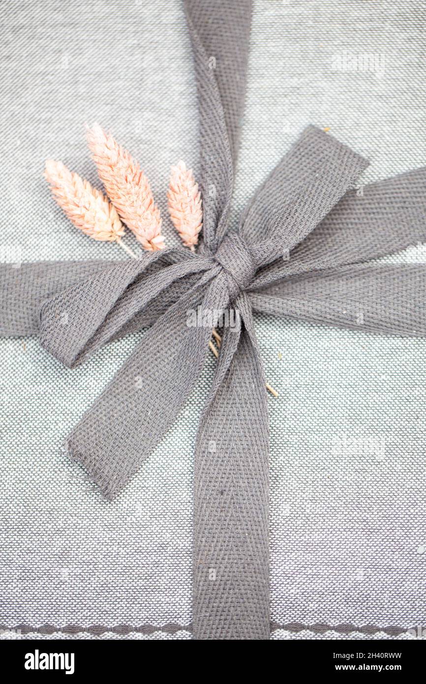 Close up cute grey ribbon bow on a grey linnen package Stock Photo - Alamy