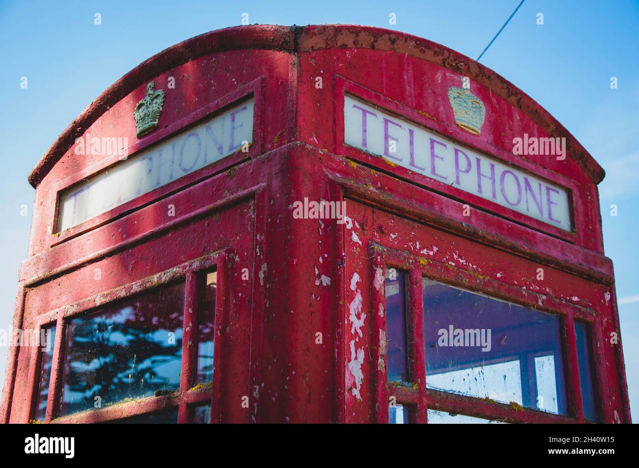 Traditional British telephone box under a blue sky Stock Photo - Alamy