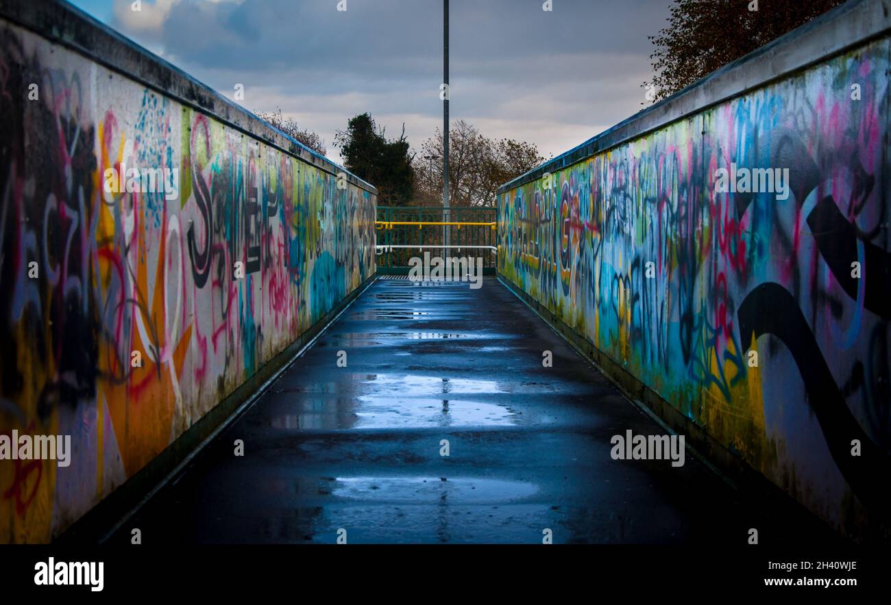 Colourful graffiti on pedestrian commuter railway bridge showing ...