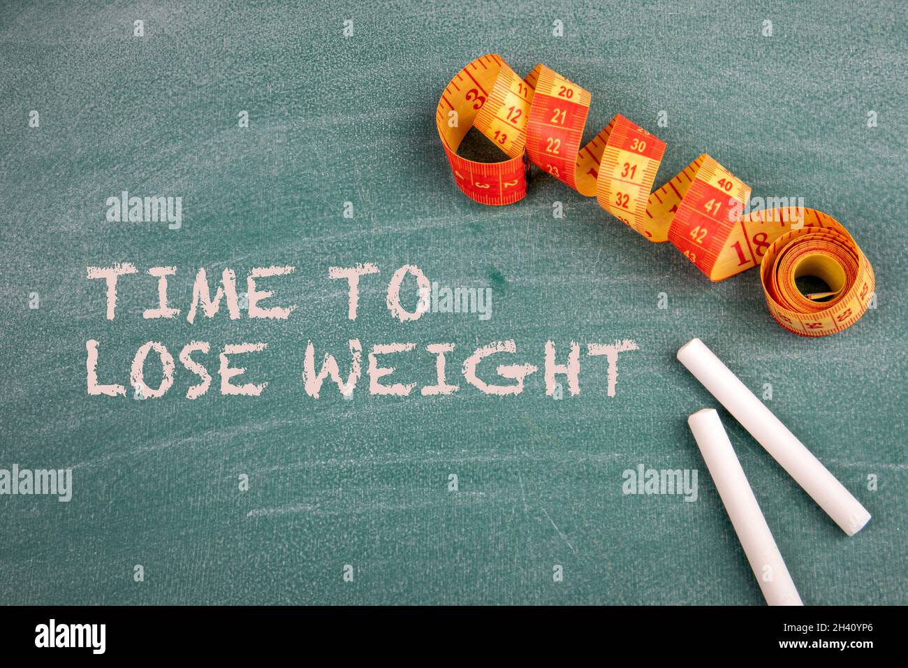 Time To Lose Weight. Tape measure and pieces of chalk on a blackboard ...