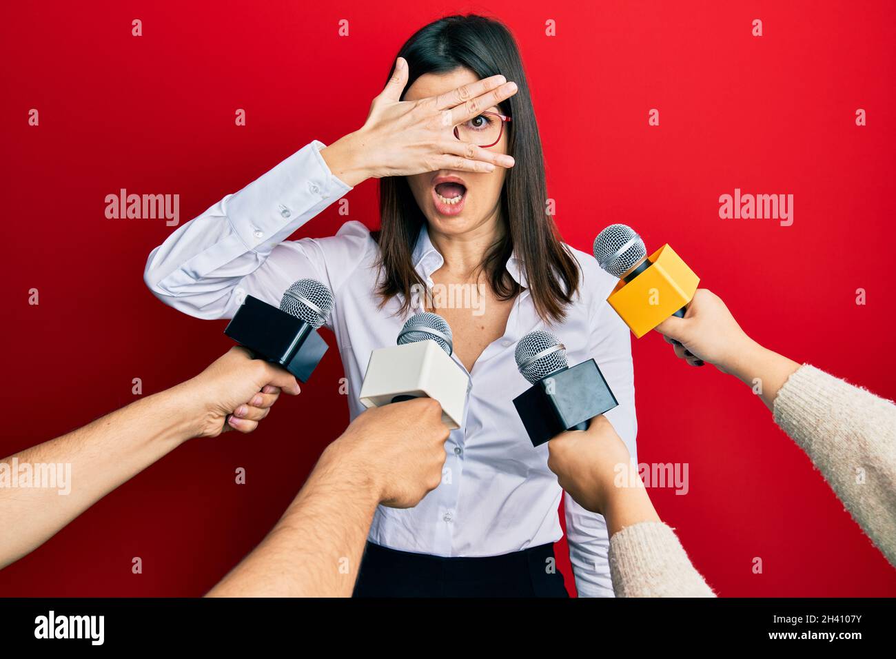 Young hispanic woman being interviewed for journalist hands with ...