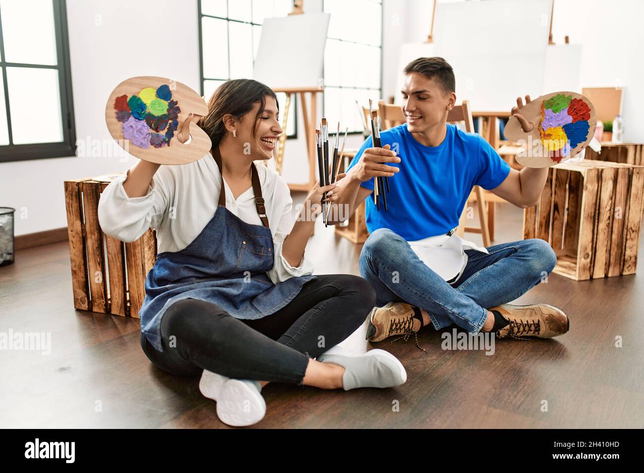 Two students smiling happy painting at art school Stock Photo - Alamy