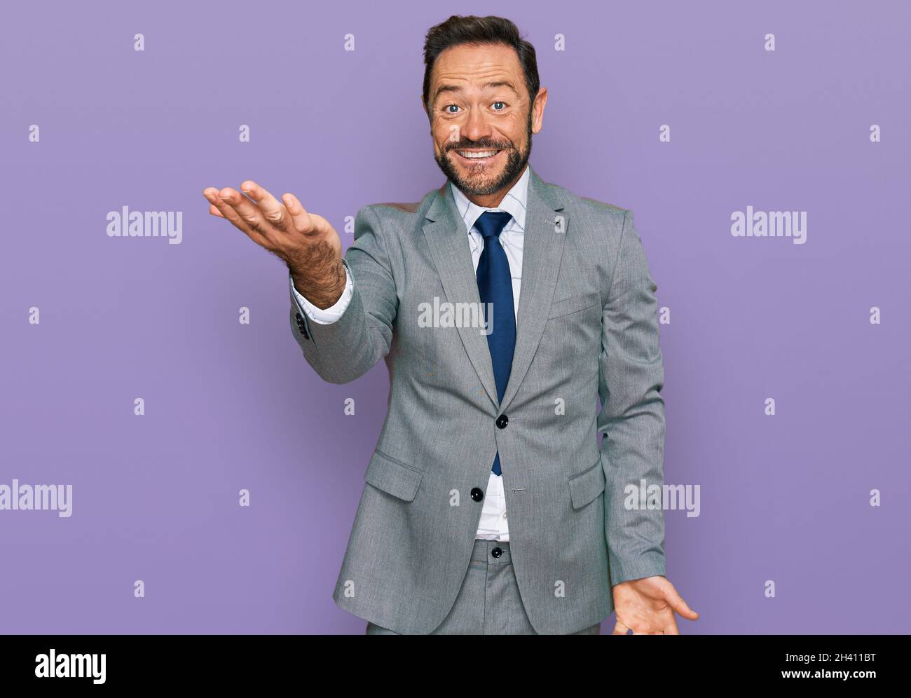 Middle age man wearing business clothes smiling cheerful with open arms ...