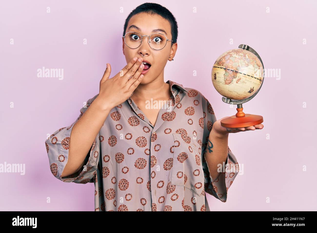 Beautiful hispanic woman with short hair holding small world ball ...