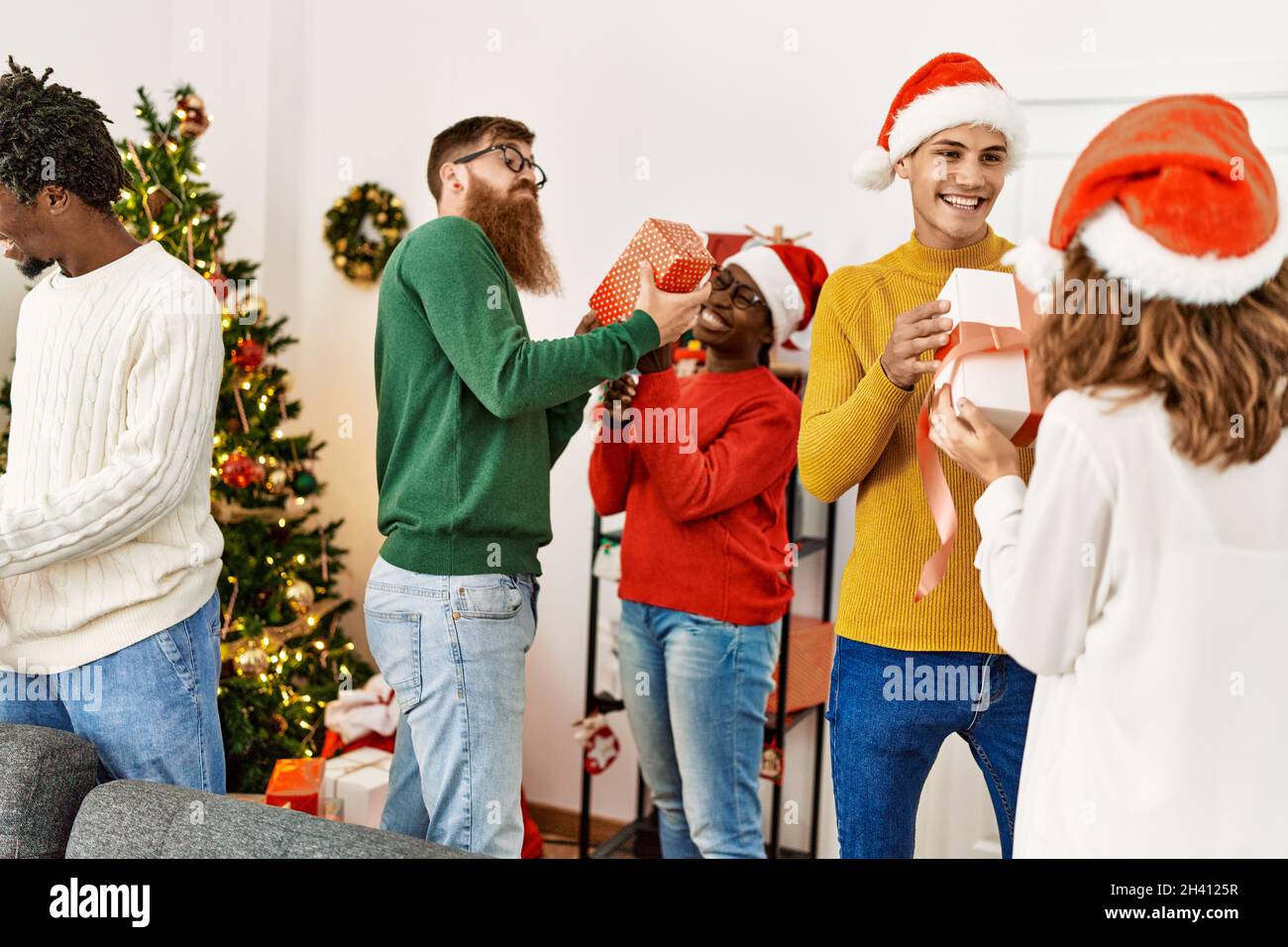 Group of young people giving christmas gifts at home Stock Photo - Alamy