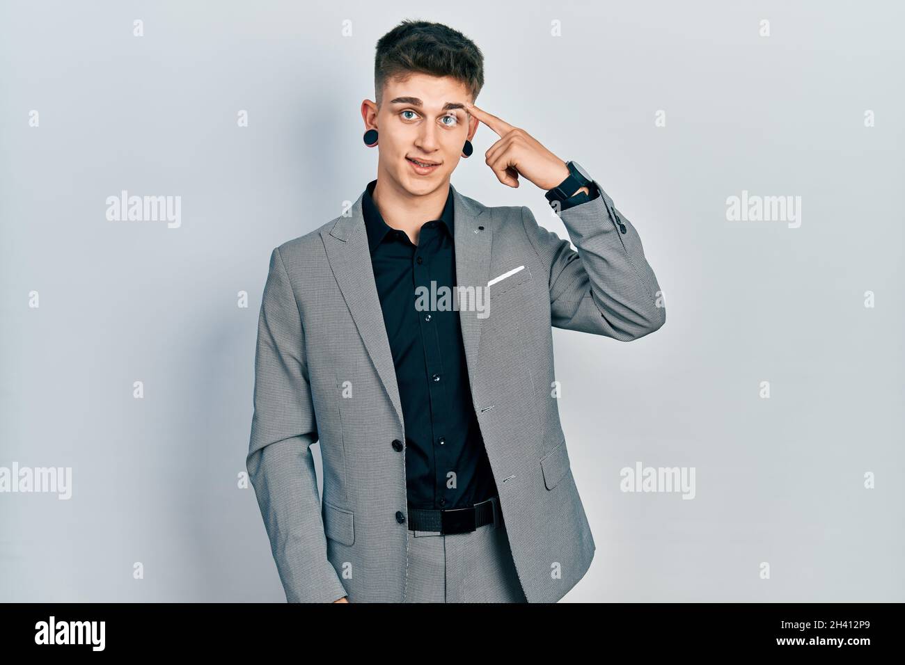 Young caucasian boy with ears dilation wearing business jacket smiling ...