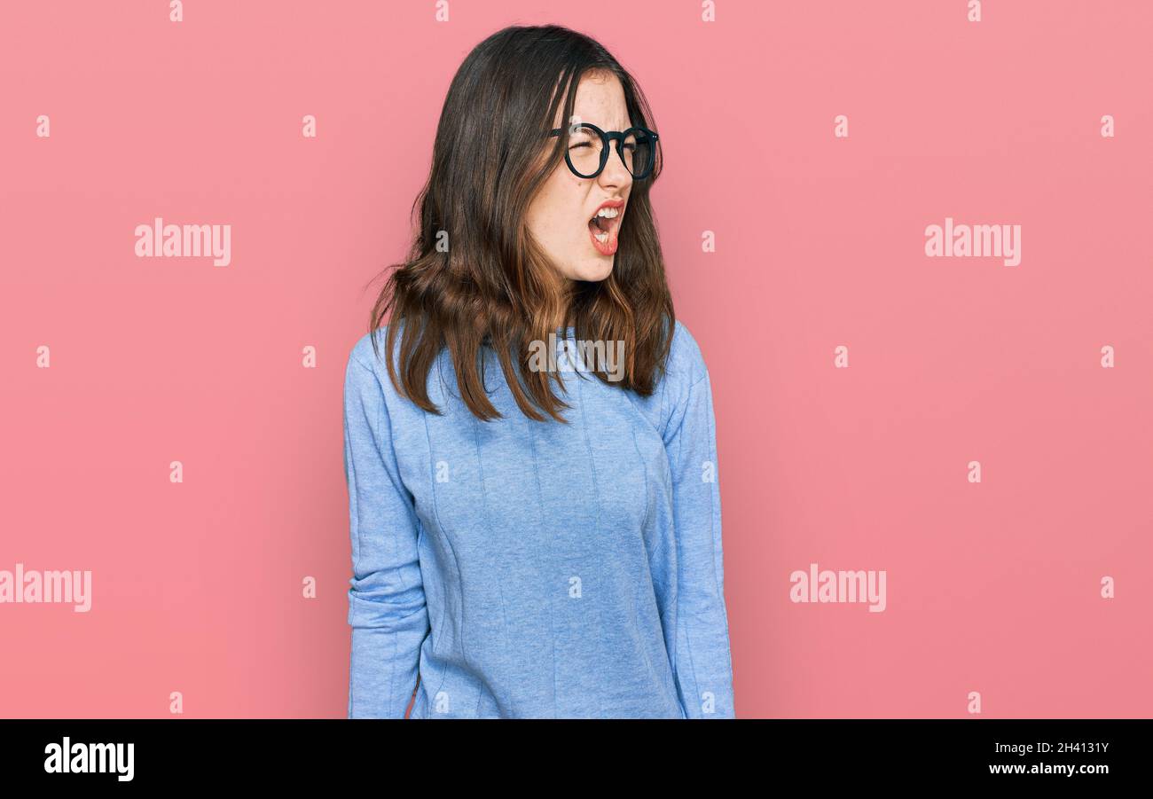 Young beautiful woman wearing casual clothes and glasses angry and mad ...