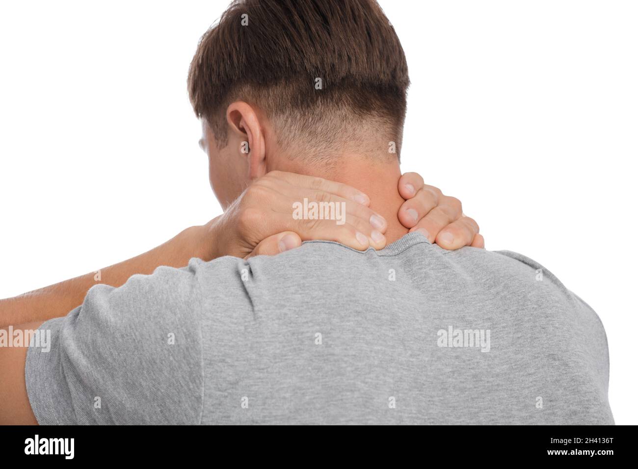 Young european man suffering from neck pain and pressing hand to sore ...
