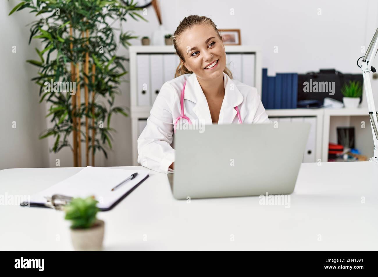 Young blonde girl wearing doctor uniform working at clinic Stock Photo ...