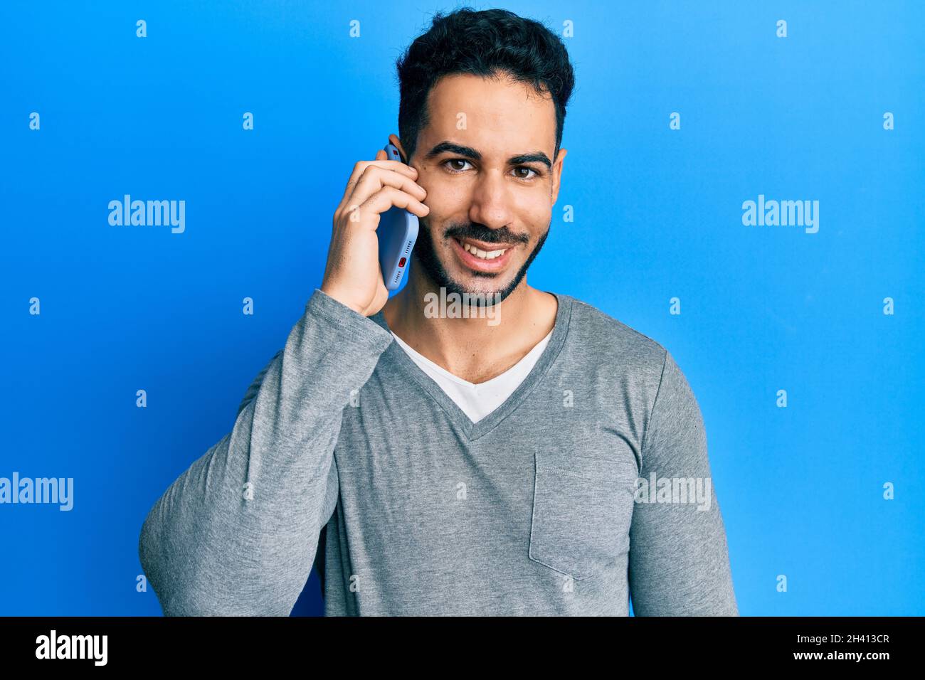 Young hispanic man having conversation talking on the smartphone ...