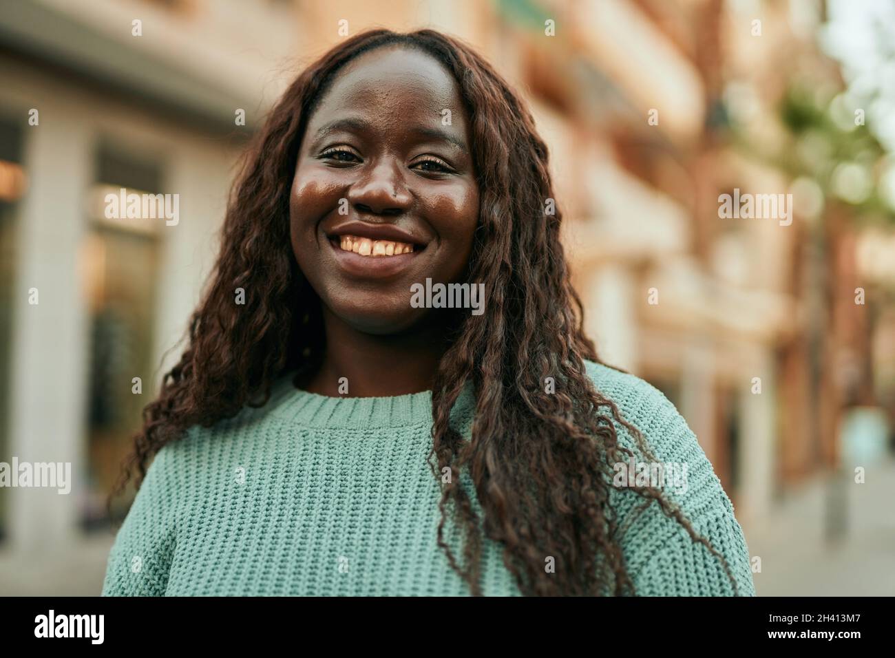 Young african woman smiling happy at the city Stock Photo - Alamy