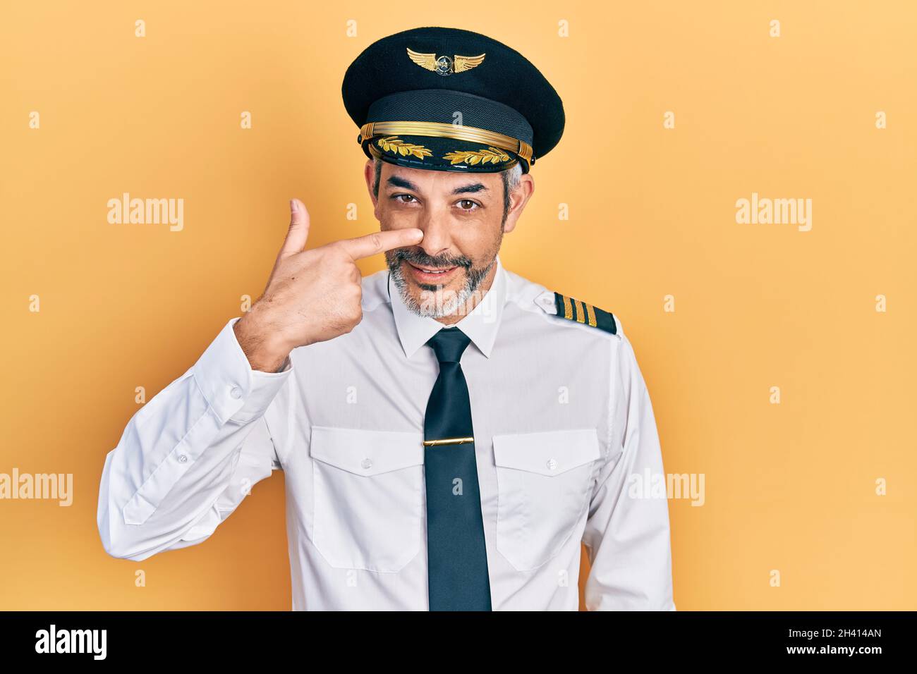 Handsome middle age man with grey hair wearing airplane pilot uniform ...