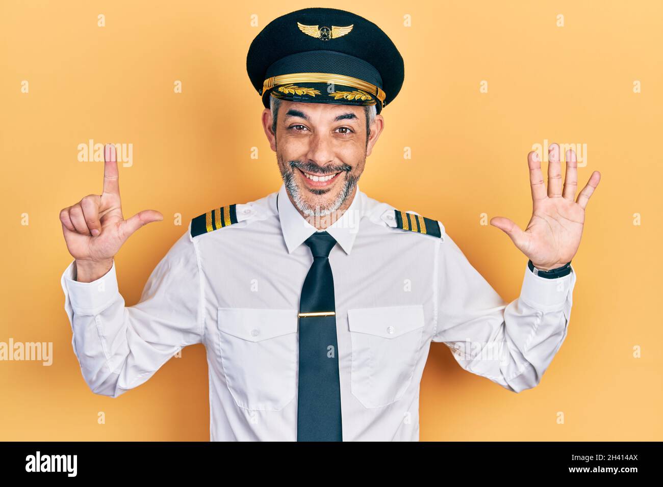 Handsome middle age man with grey hair wearing airplane pilot uniform ...