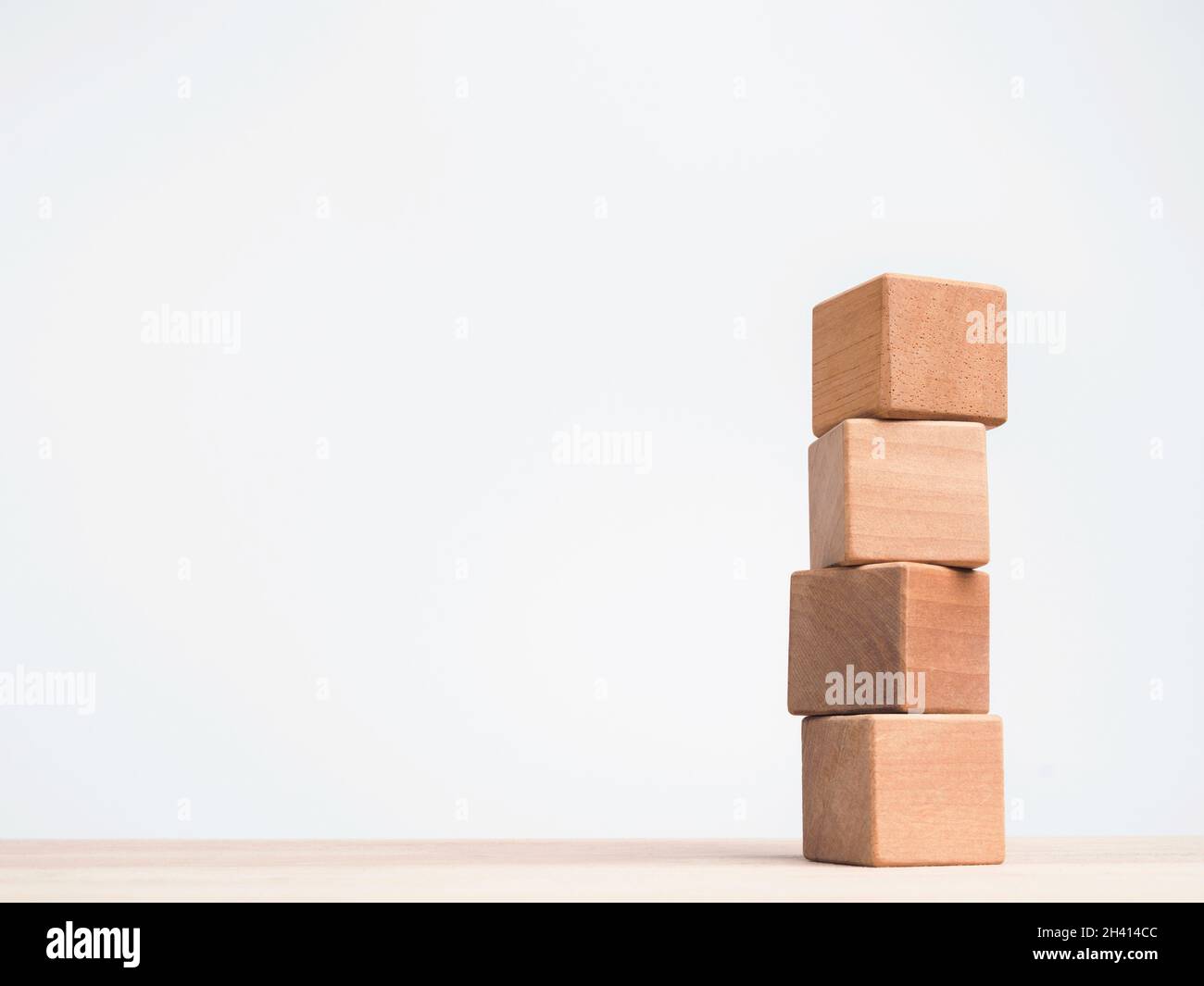 Four empty wooden cube blocks stack on the table on white background ...