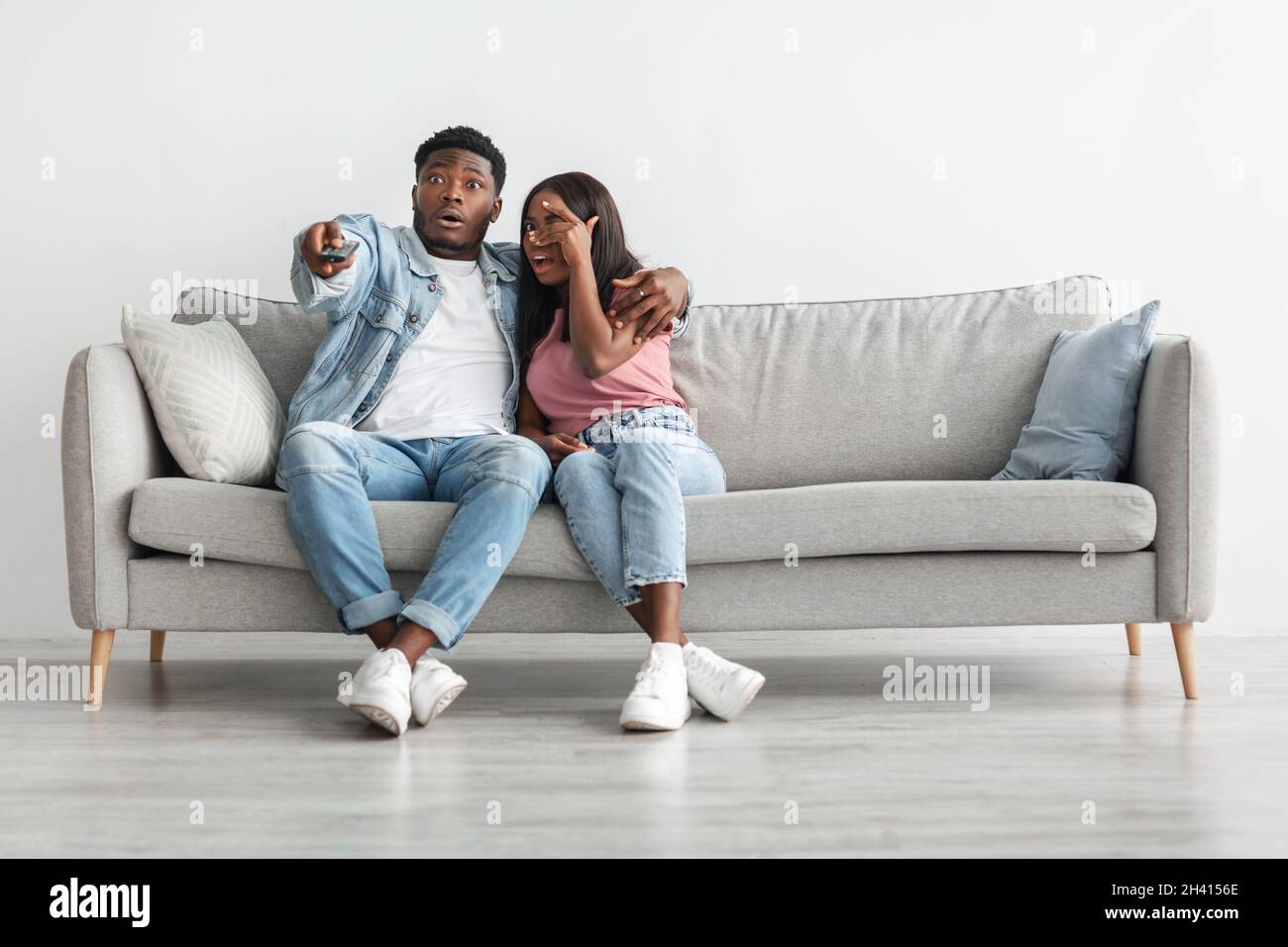 Scared African American couple spending weekend together watching ...