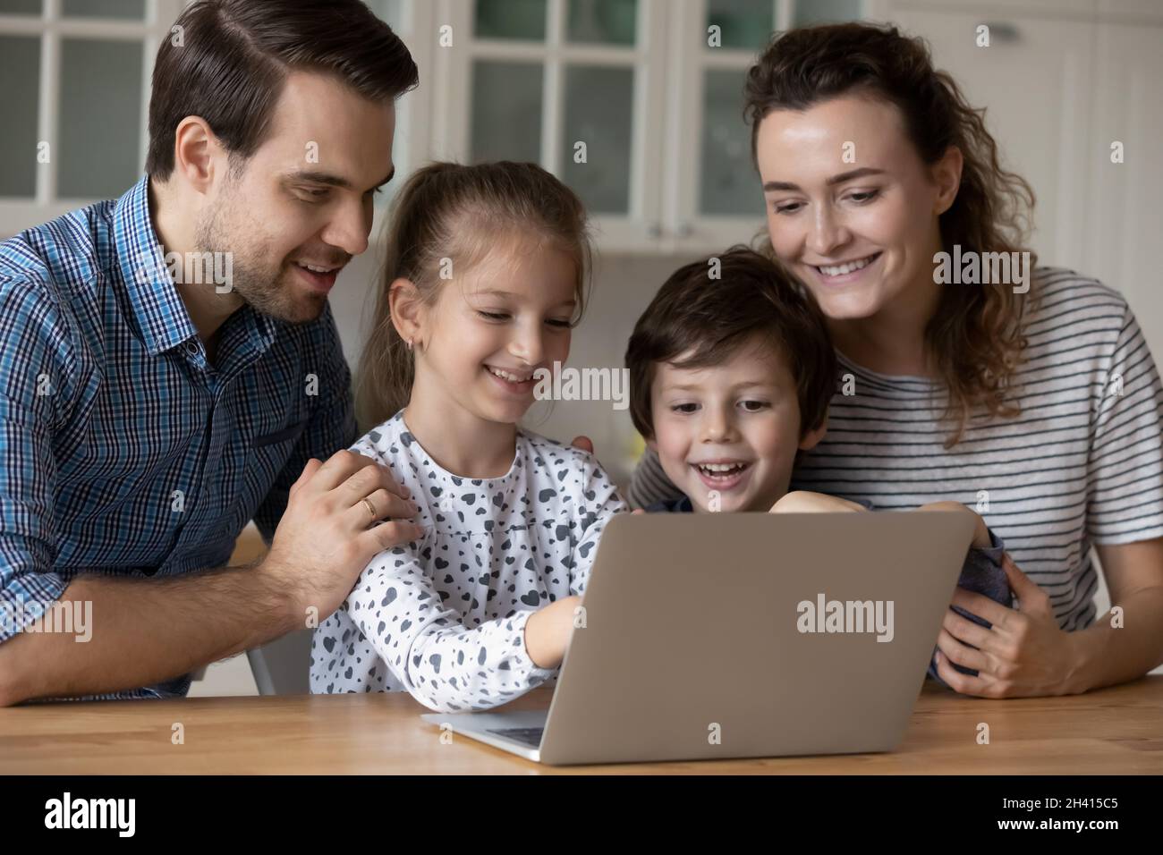 Happy small kids using computer apps with couple parents Stock Photo ...