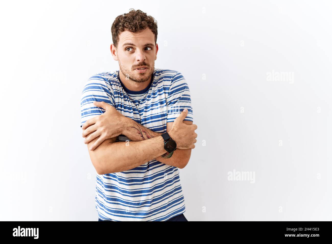Handsome young man standing over isolated background shaking and ...