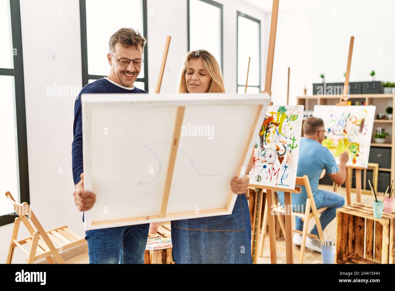 Group of middle age people drawing at art studio. Two students smiling ...