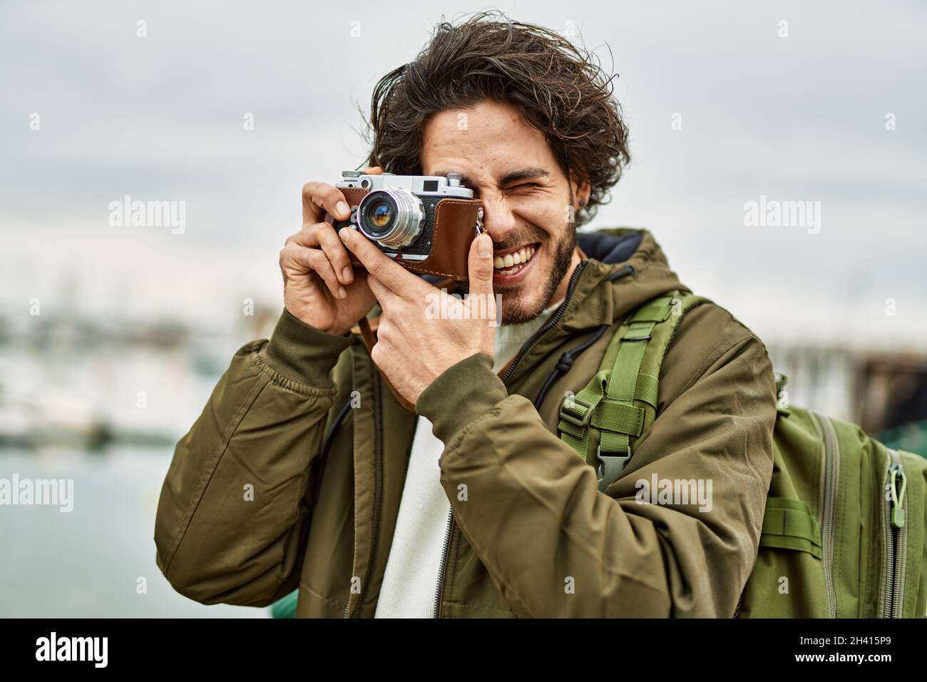 Handsome hispanic man using vintage camera by marina port Stock Photo ...
