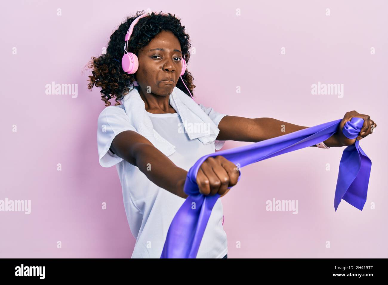Young african american woman training arm resistance with elastic arm ...