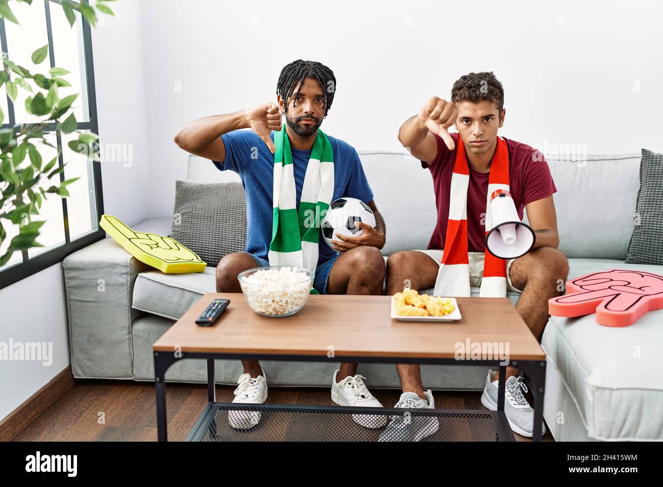 Young hispanic brothers football hooligans holding ball and megaphone ...