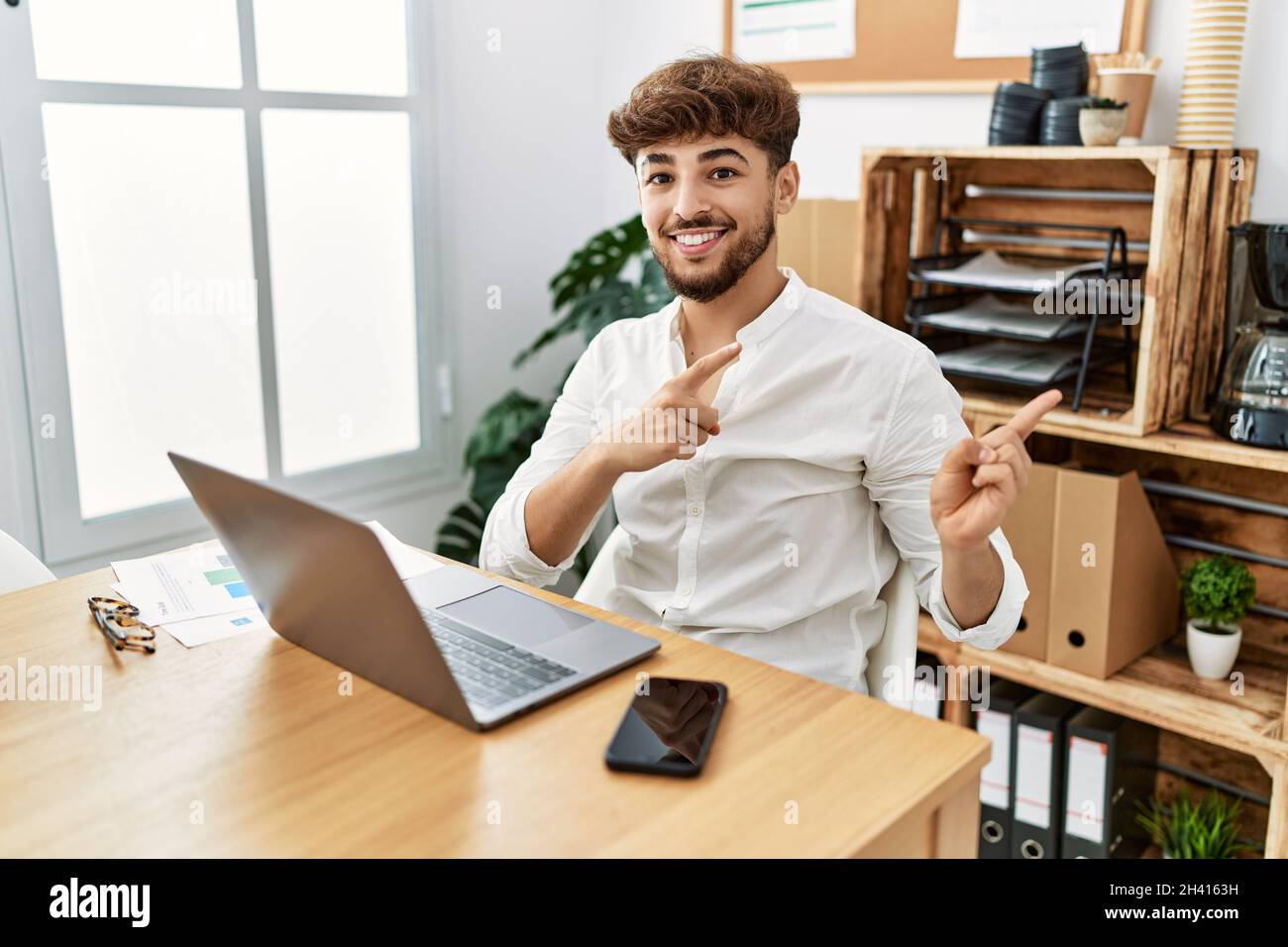 Young arab man working using computer laptop at the office smiling and ...