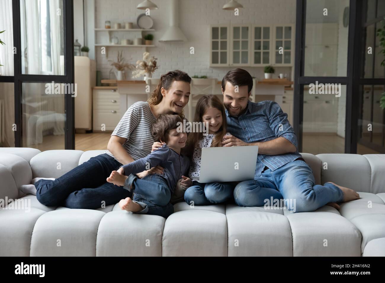 Happy young parents and adorable little children using computer Stock ...