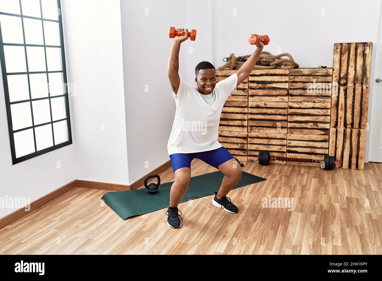 Young african man training with dumbbells at the gym Stock Photo - Alamy