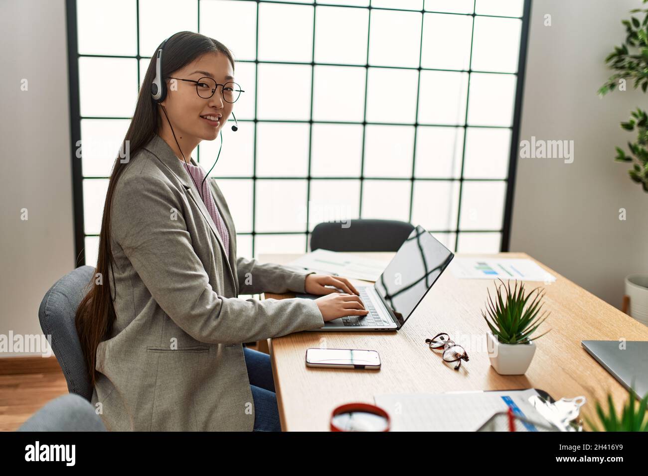 Young chinese call center agent woman smiling happy working at the ...
