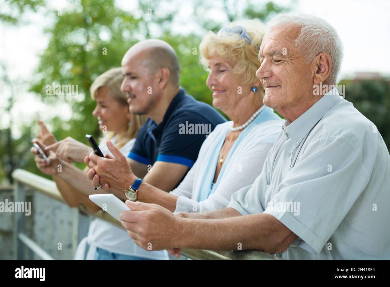 four friends texting in phones in the park Stock Photo - Alamy