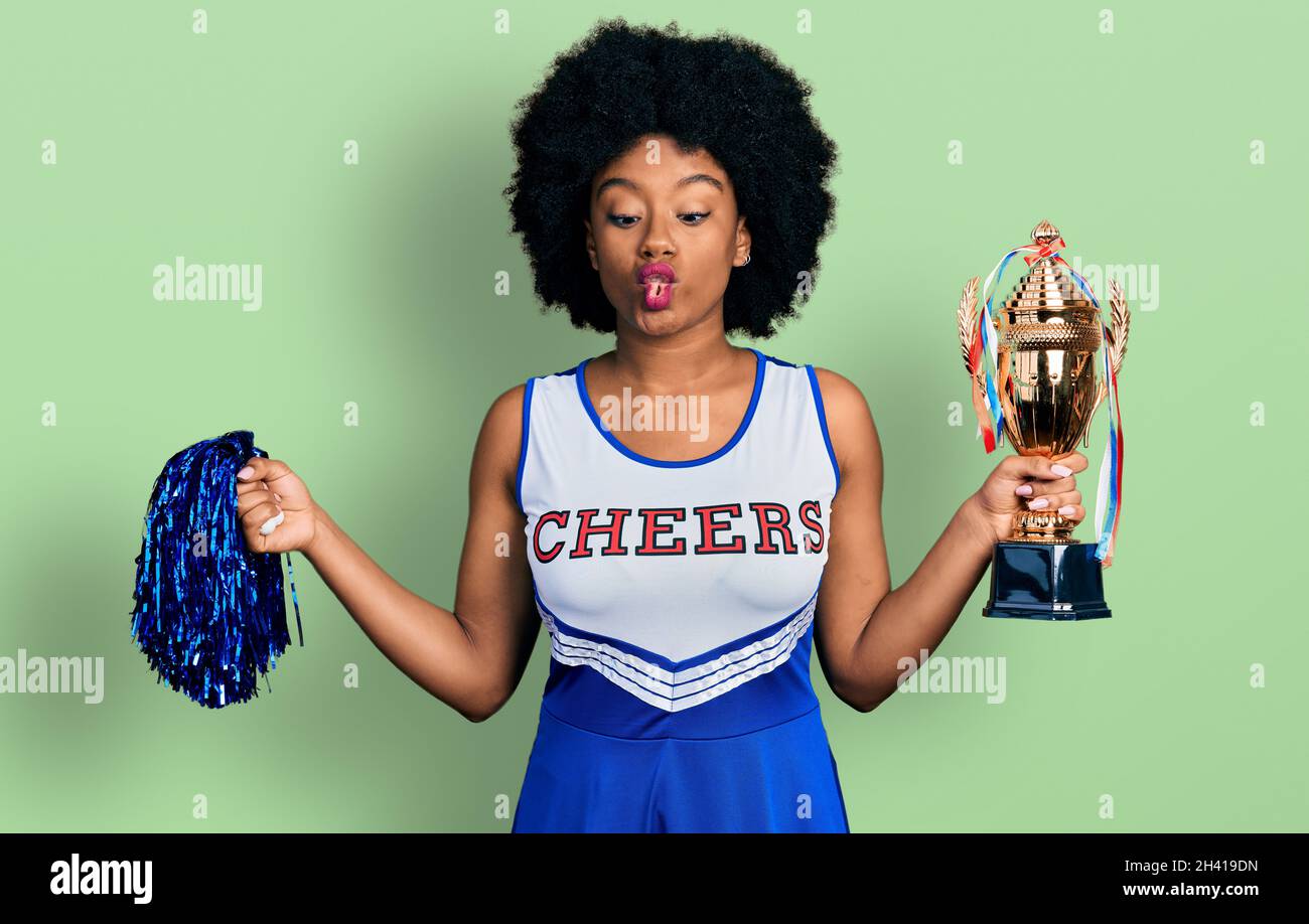 Young african american woman wearing cheerleader uniform holding pompom ...